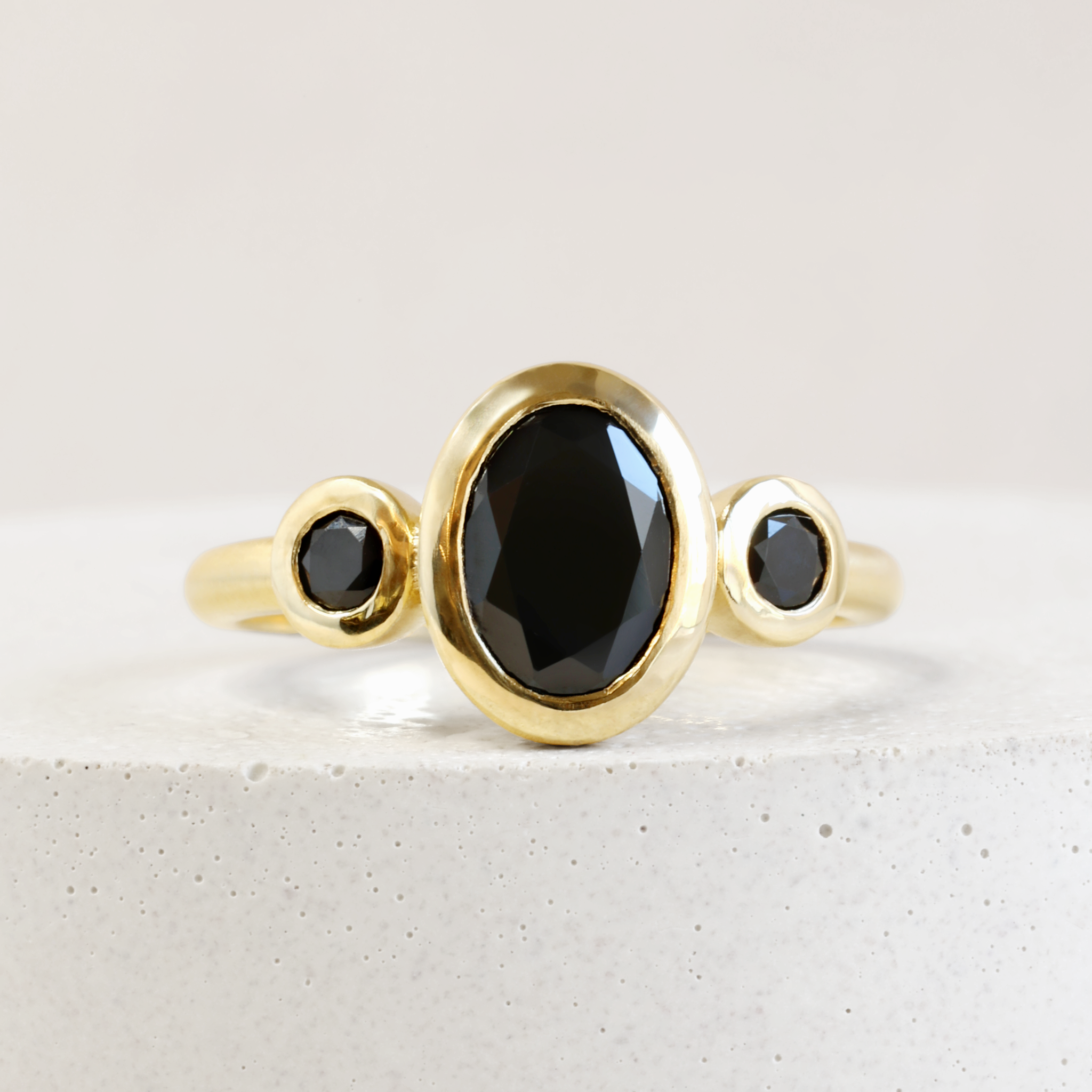 Black Spinel Three Stone Wren Bezel Ring in Yellow Gold